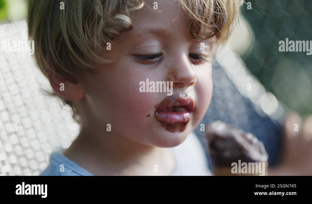 Cute little boy eating ice cream. Male child eats chocolate icecream ...
