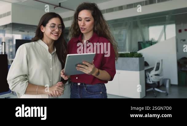 Two women using tablet shaking hands finish formal collaborative meeting in office, express ...