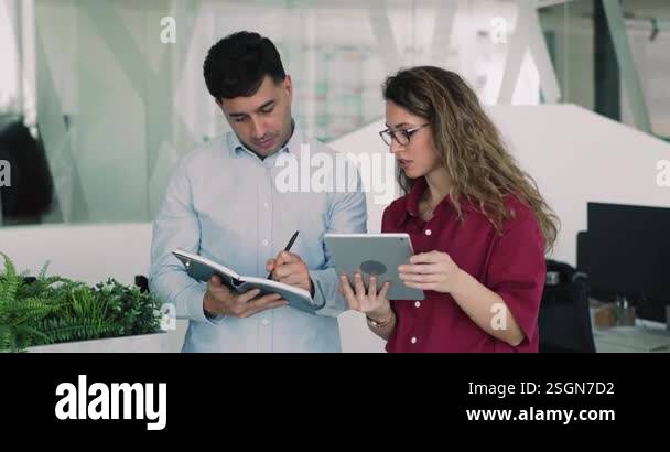 Woman hold tablet engaged in teamwork with colleague, provide details ...