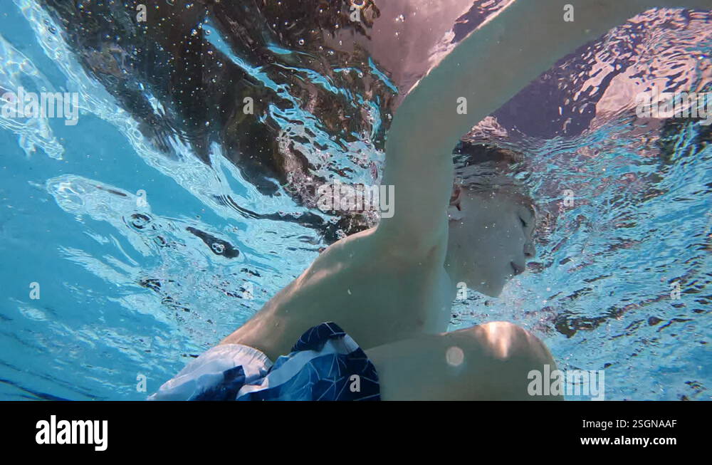 Young boy trying to tread water in pool struggles to stay above water ...