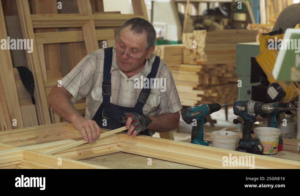 Woodworker is combining multiple handcrafted wooden window frame planks ...
