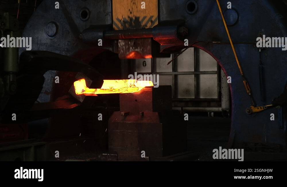 Blacksmith factory. Forging a large hot metal billet with an industrial ...