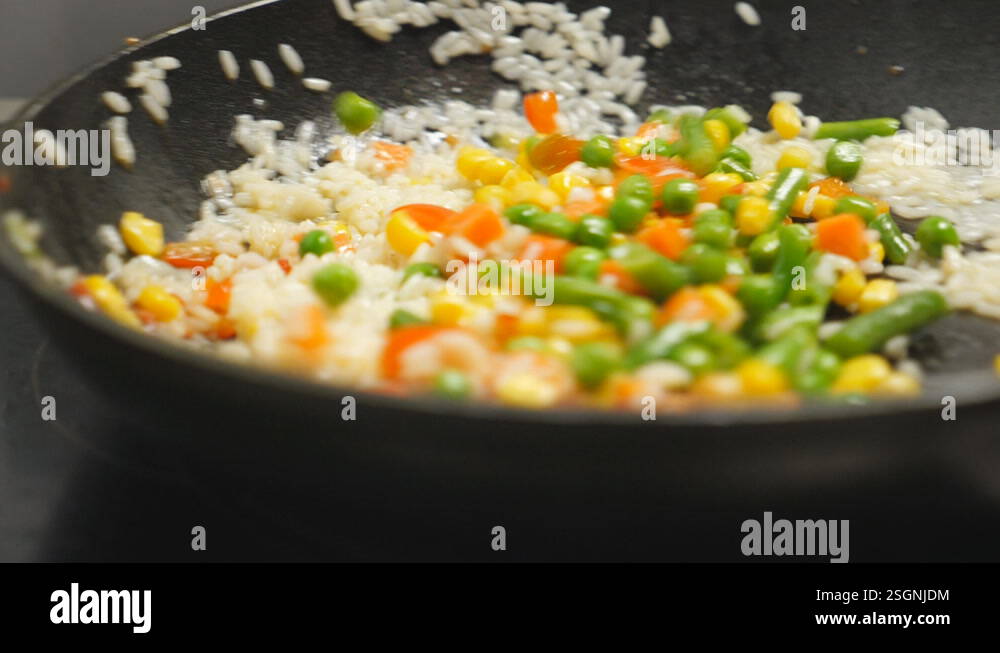 Cloes up of male cook holding frying pan and sauteing a rice Stock ...