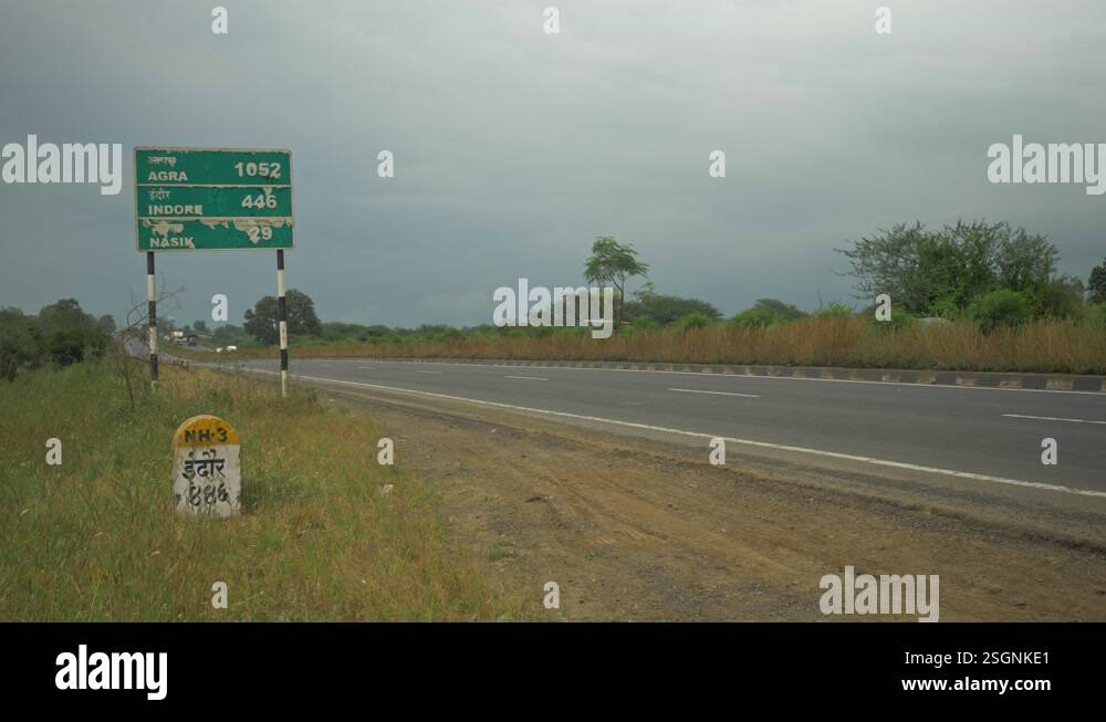 A green sign board shows distance of major cities on National Highway ...