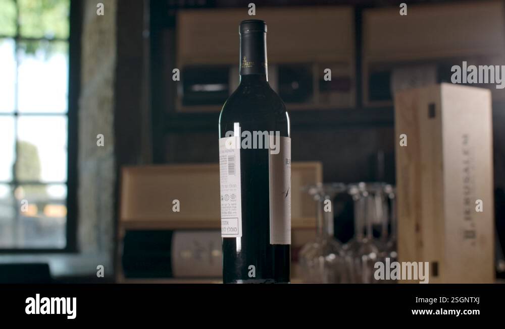 A shiny bottle of wine on a rotating surface, inside a living room ...