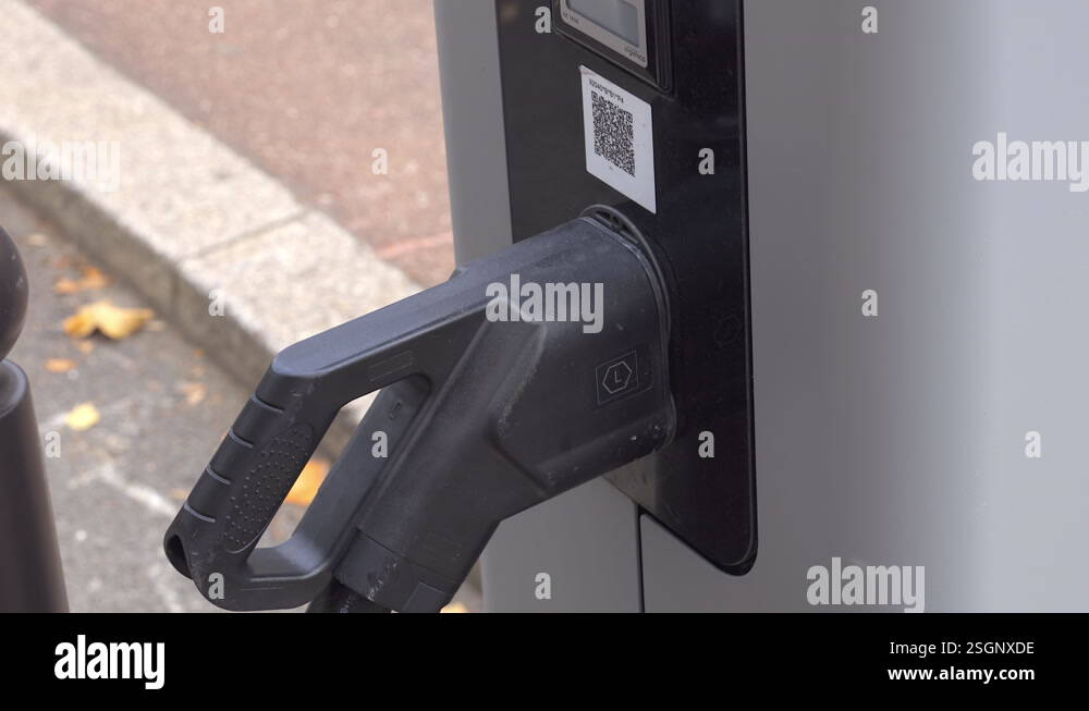 Hand of a man connecting a cable of a CCS type 2 socket spot to a ...