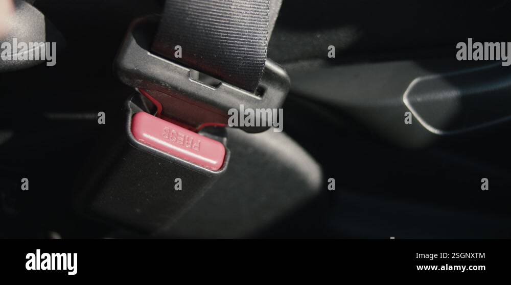 Female hand buckles up releases safety belt woman in car in close up ...