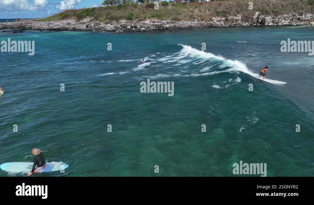 Surfers paddle out, sit on surfboard, read ocean to catch next set ...