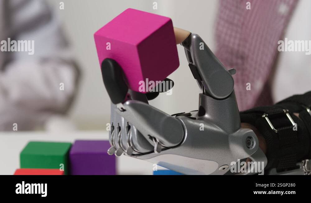 Futuristic bionic robot hand picks up and moves colored cubes Stock ...