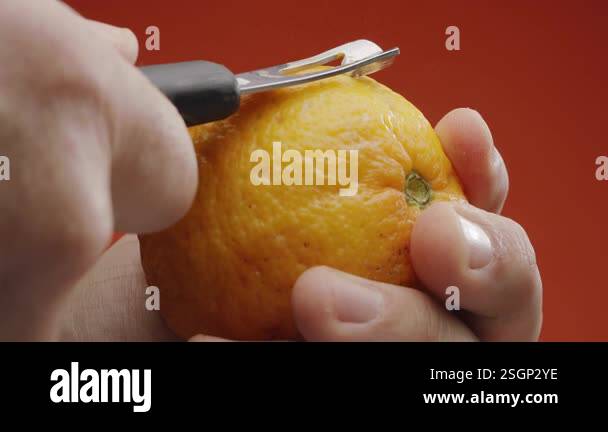 Getting orange peel with a special kitchen tool; orange juice with ...
