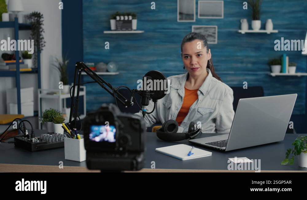 Attractive social media influencer sitting at home studio desk while ...