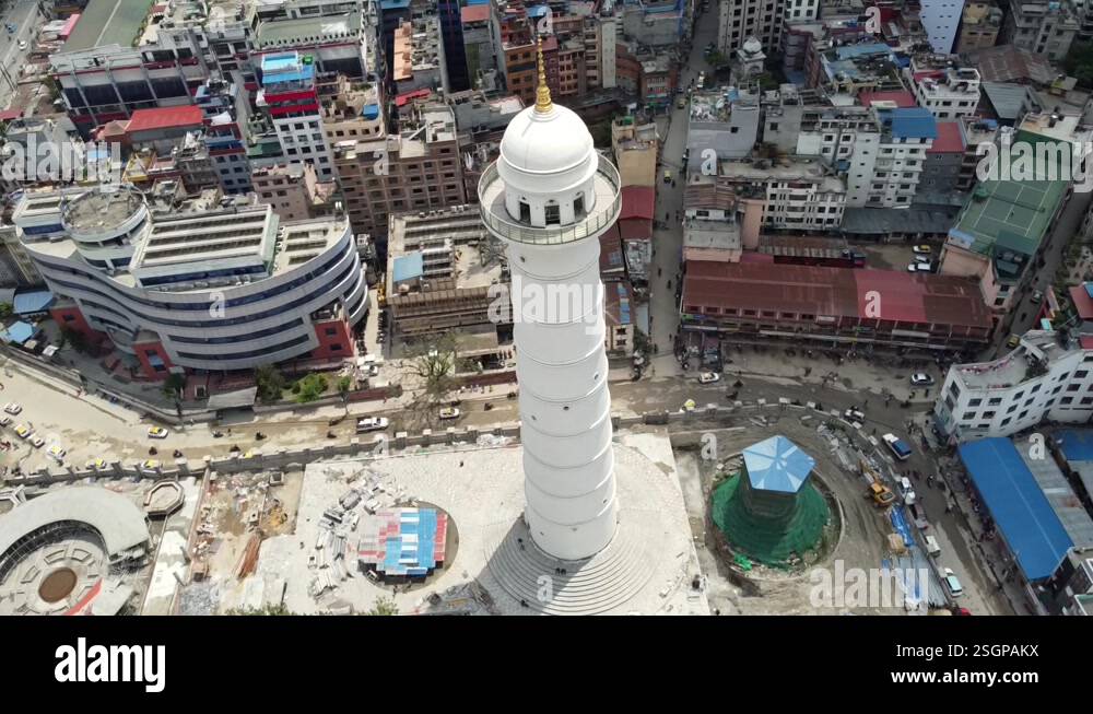A circling aerial view of the Dharahara Tower with the city of ...