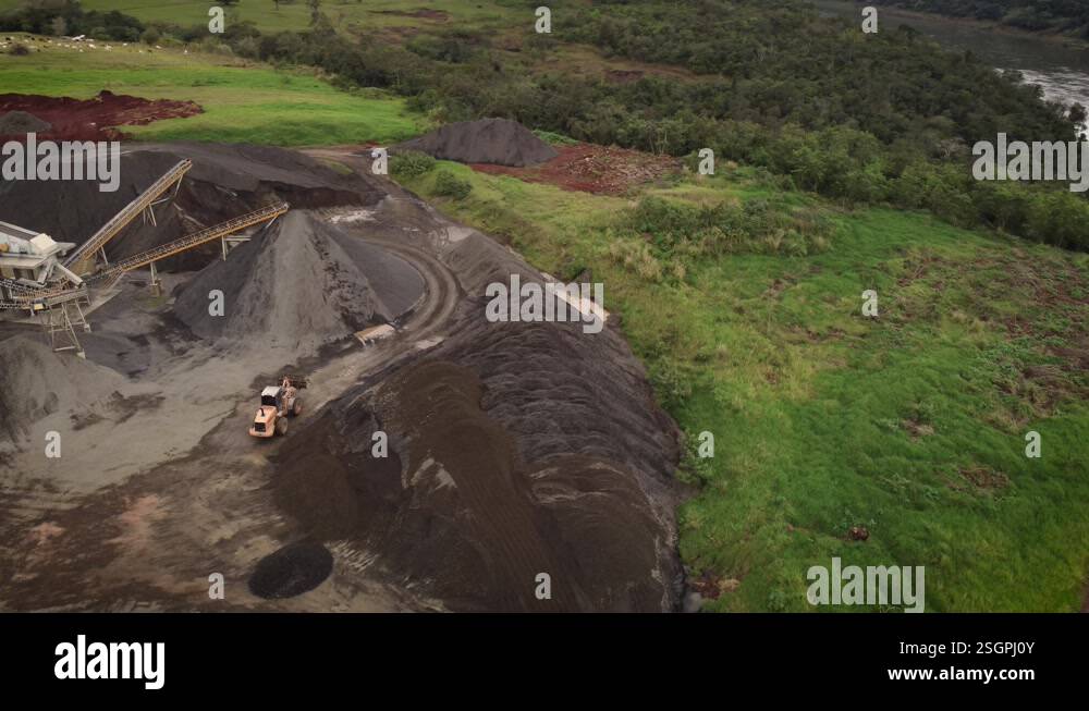 Excavator working in open stone quarry mine, Brazil near Iguazù river ...