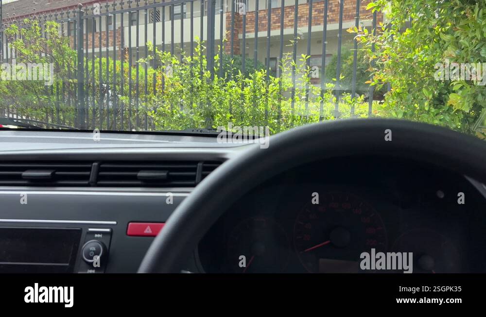 Dashboard of a parked car in front of flats with trees in the wind ...