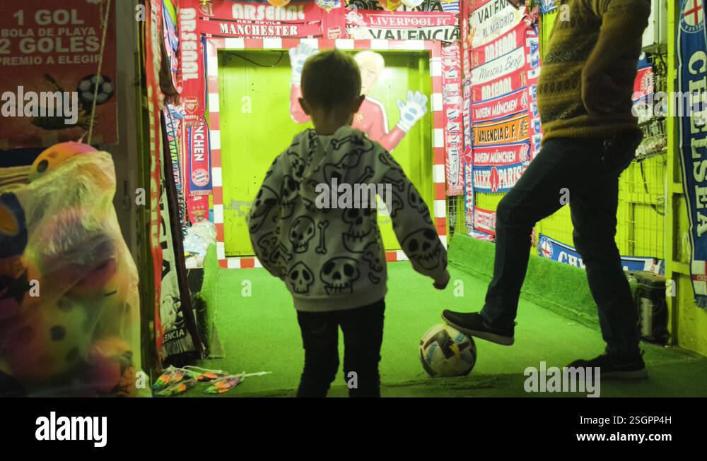 Young boy having fun at Penalty kick mechanical attraction in Funfair ...
