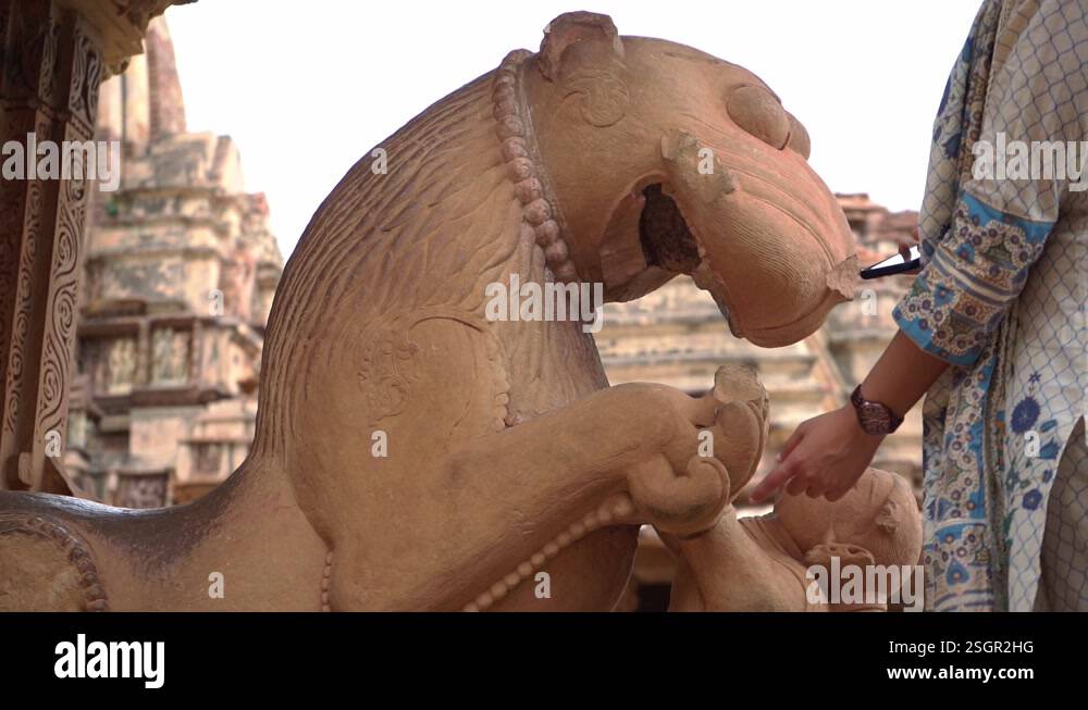 Indian Woman Tourist Standing, Touching The Statue Of A Lion And Woman ...