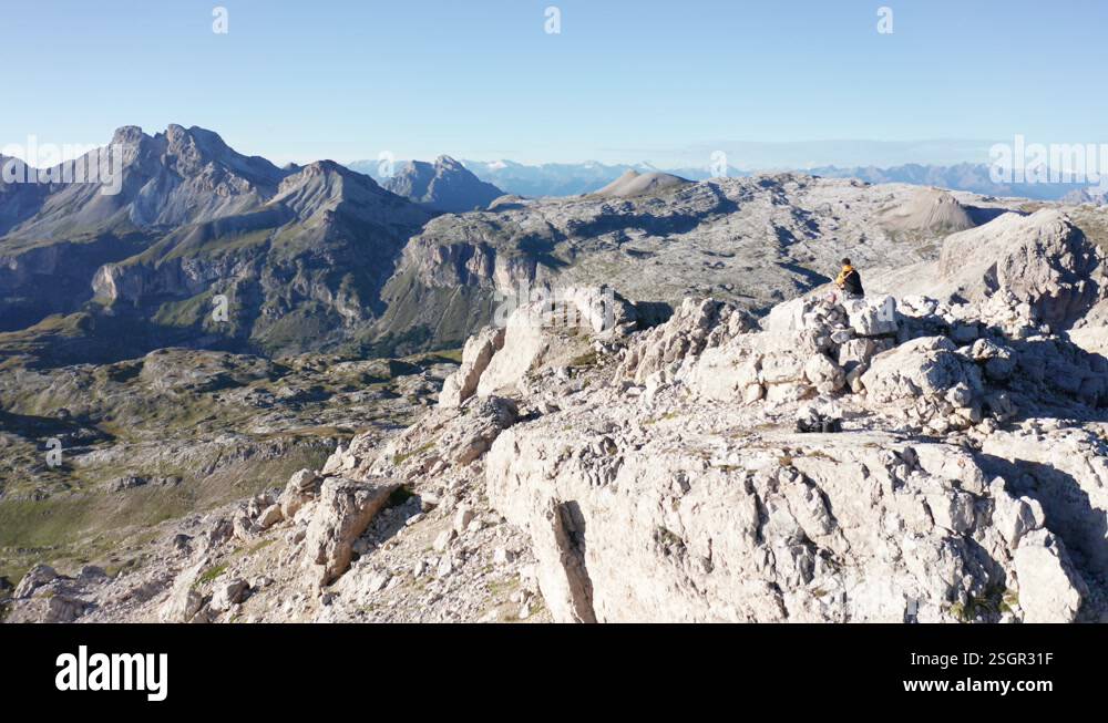 Alpine climber sitting on mountain peak in Dolomites, aerial view Stock ...