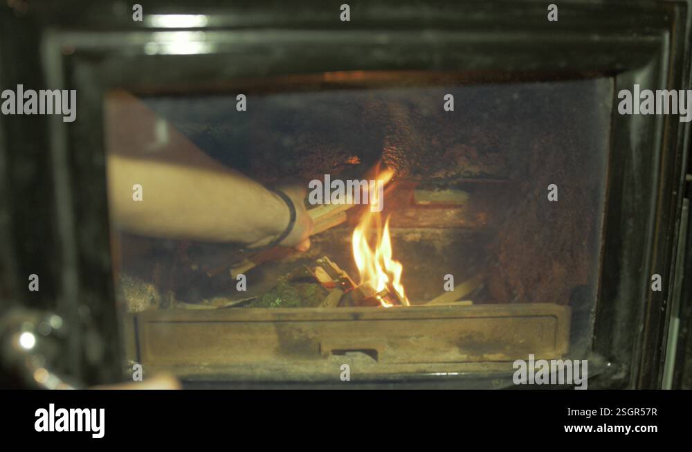 Man lighting fire adding kindling to wood burning stove Stock Video ...