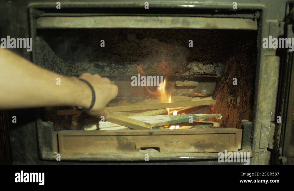 Adding kindling sticks to wood burning stove fire Stock Video Footage ...