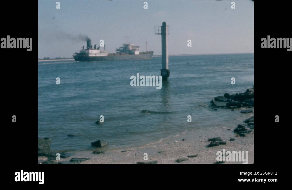 1950s: Ship sailing away, water lapping at the beach. Ships sailing ...