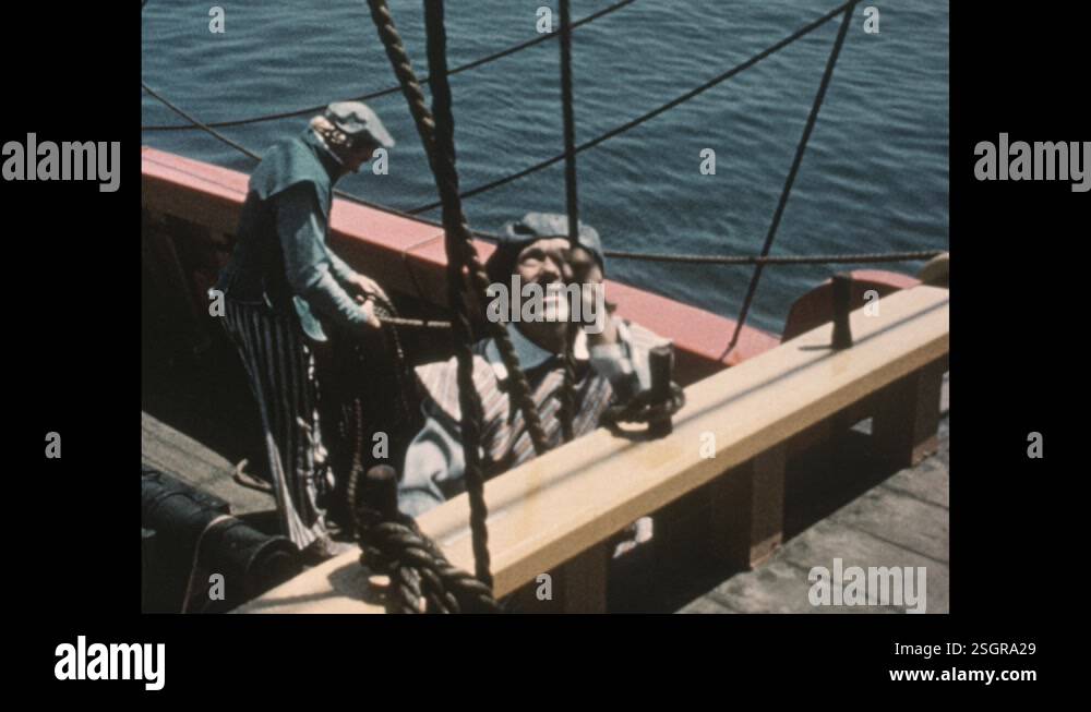 1970s: Man pulls rope on deck of ship. Man climbs rigging Stock Video ...