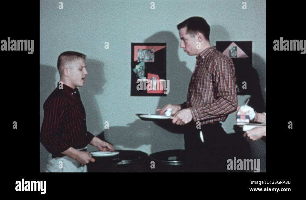 1950s: Two teen boys speak as they throw out trash from their lunch ...