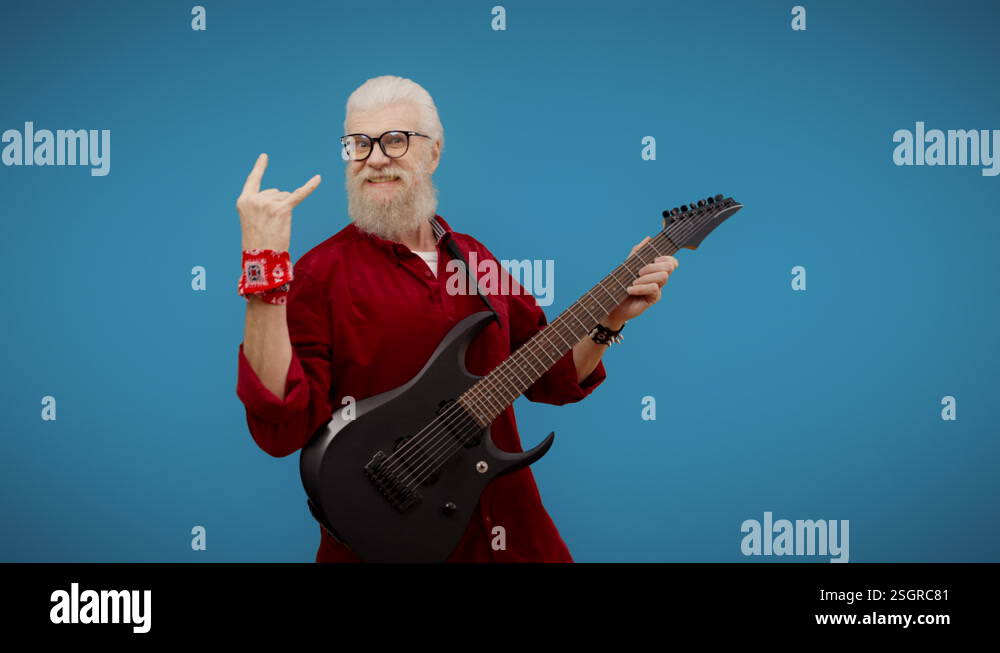 Man in his 60s showing heavy metal and hard rock horns hand gesture ...