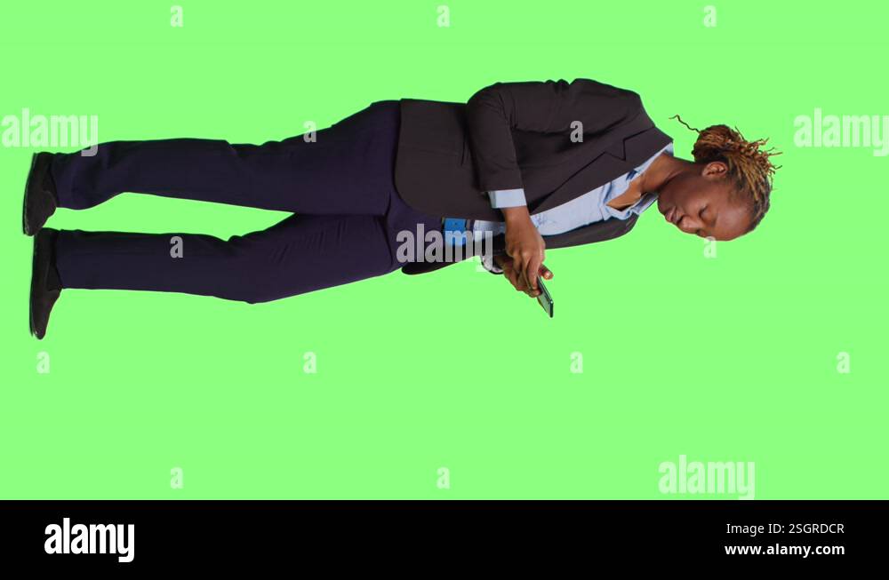 Vertical video: Full body greenscreen backdrop with businesswoman using ...