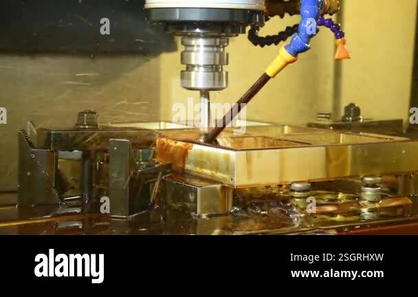 The CNC milling machine rough cutting the mold parts with oil coolant ...