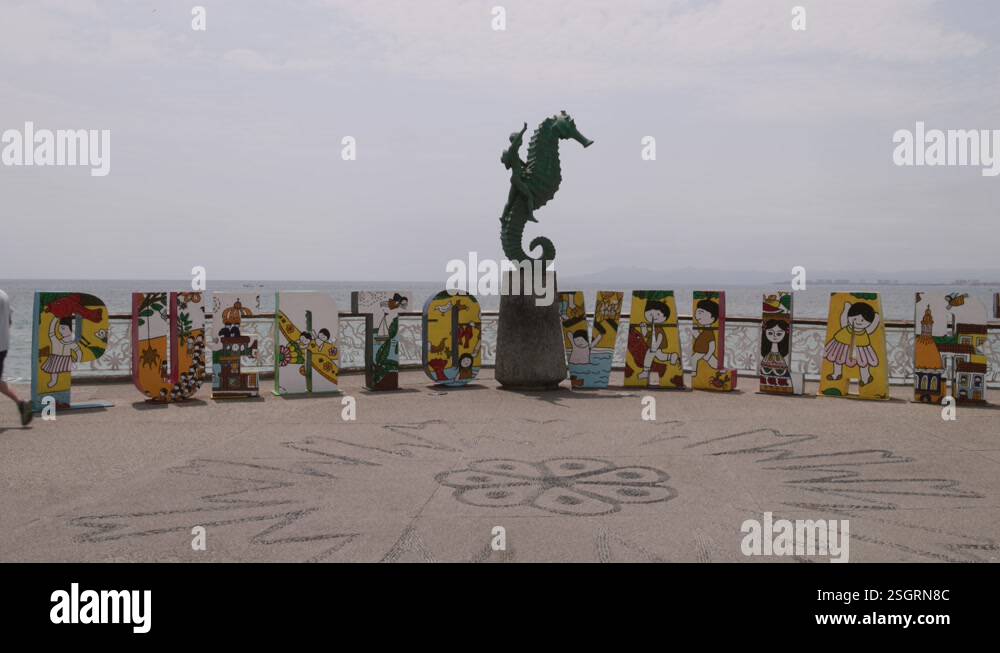 Puerto Vallarta street art and sign on the malecon with people walking ...