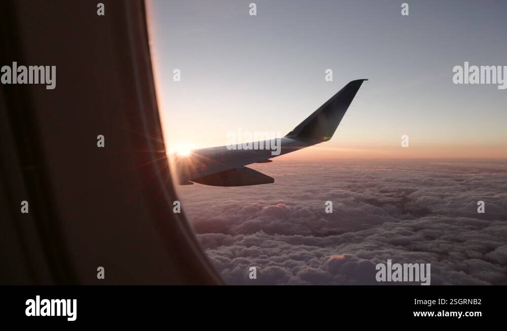 Partial reveal of airplane jet wing sun at horizon with len flare of ...