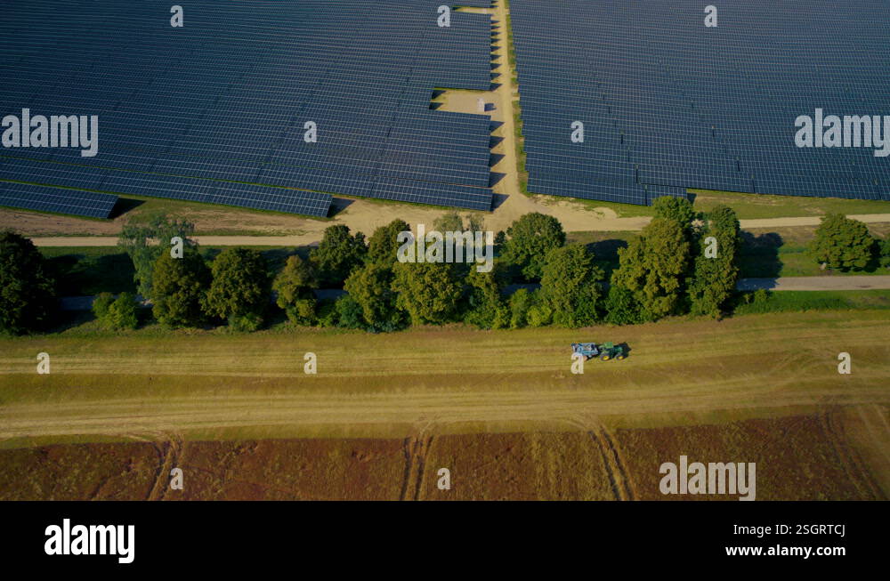 Aerial Overhead View Of Large Scale Solar Panel Farm With Tractor ...