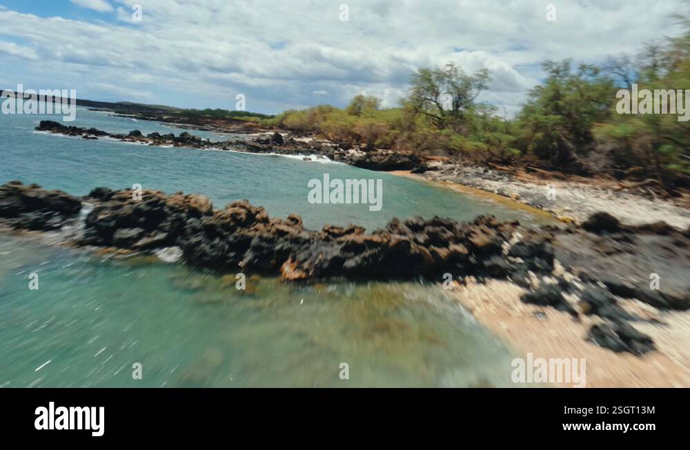Fast and low FPV drone video flying over volcanic lava rock beach in ...