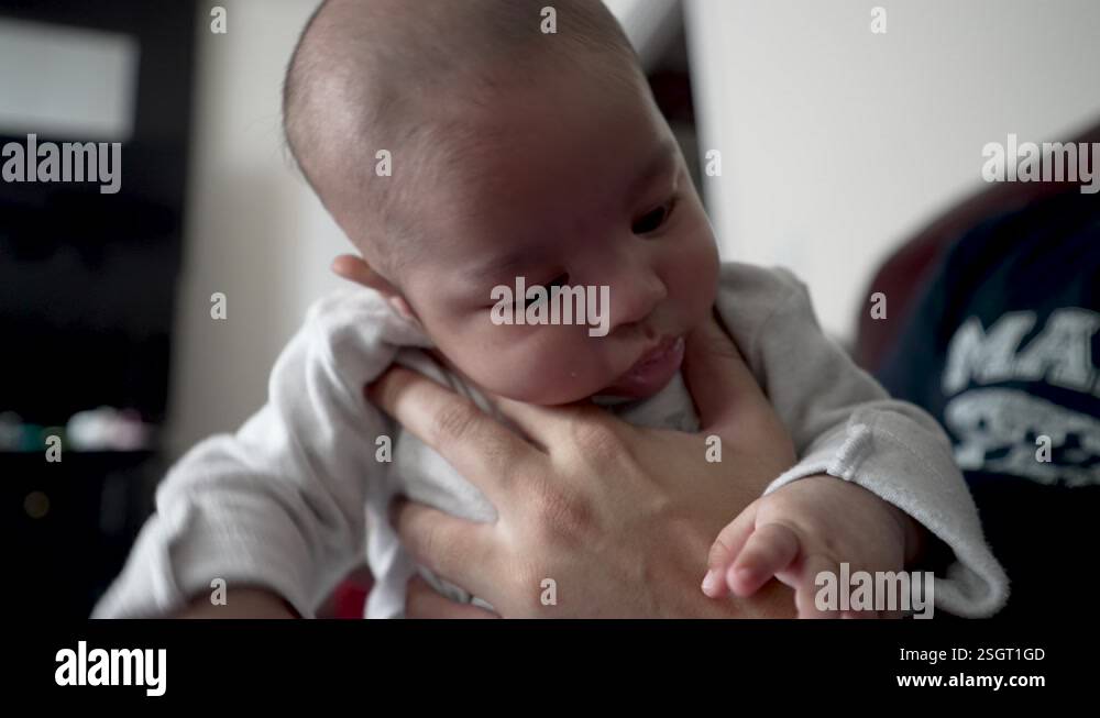 Father Gently Holding Up His 2 Month Old Son On His Front To Help Him ...