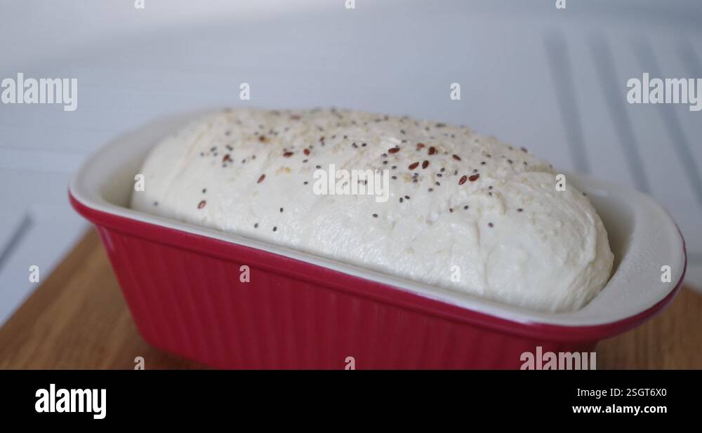 Homemade baking of bread: loaf in red ceramic form waiting for the oven ...