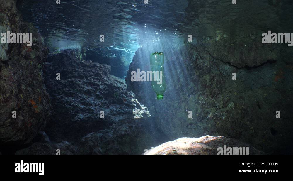 green plastic bottle in cave underwater ocean pollution with sun beams ...