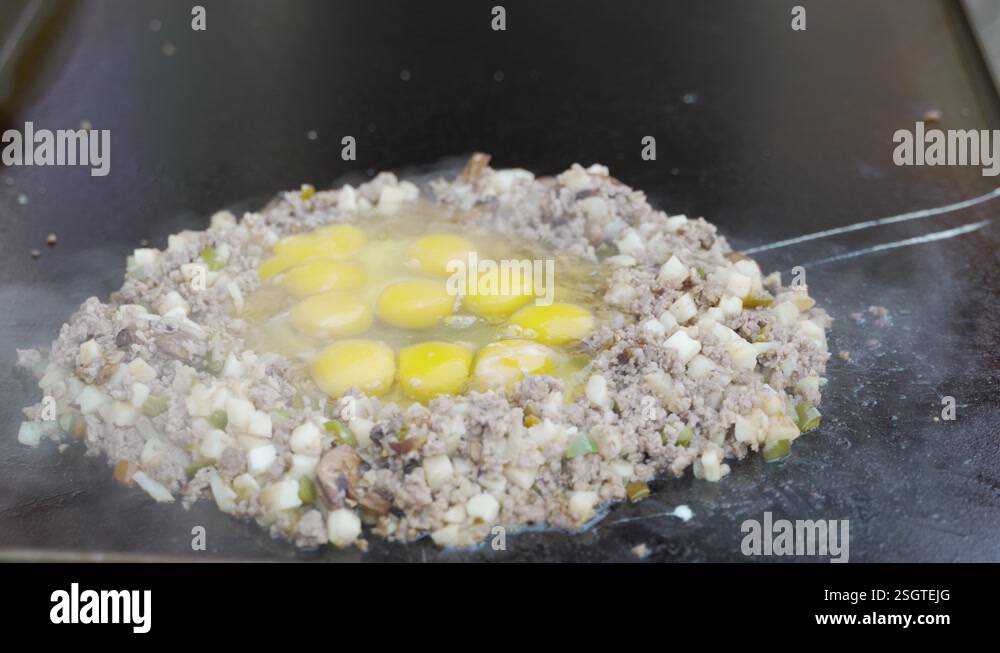 Eggs setting and cooking in a pile of ground sausage and vegetable ...