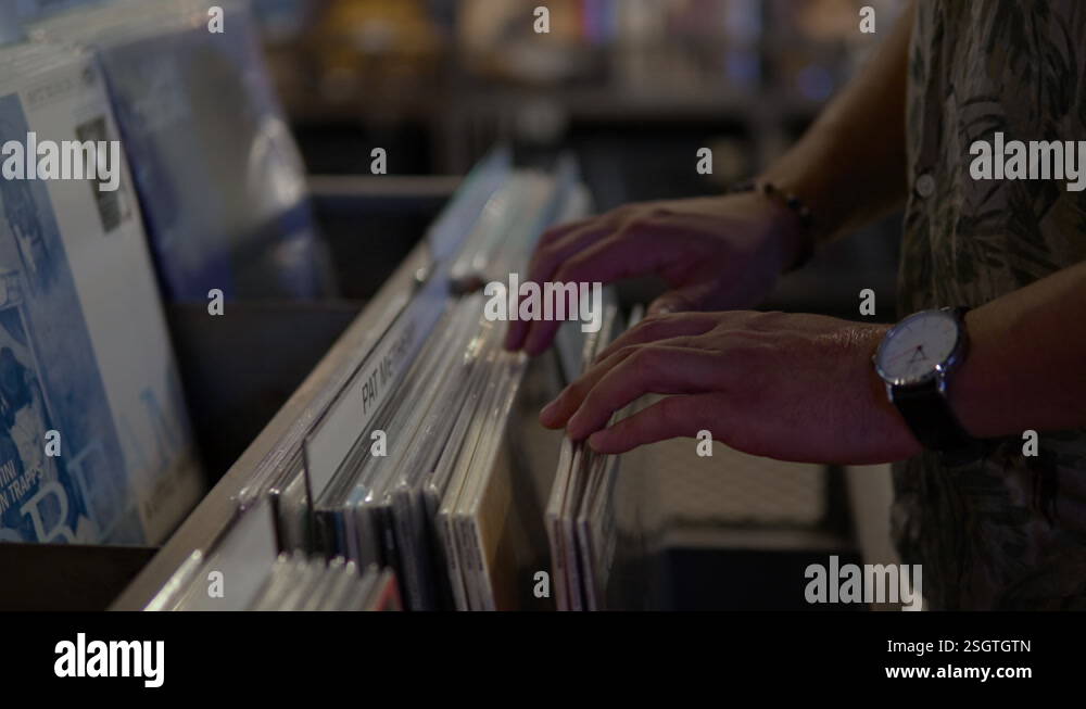 Male Customer Looking Through Vinyl Records Displayed In A Music Record ...