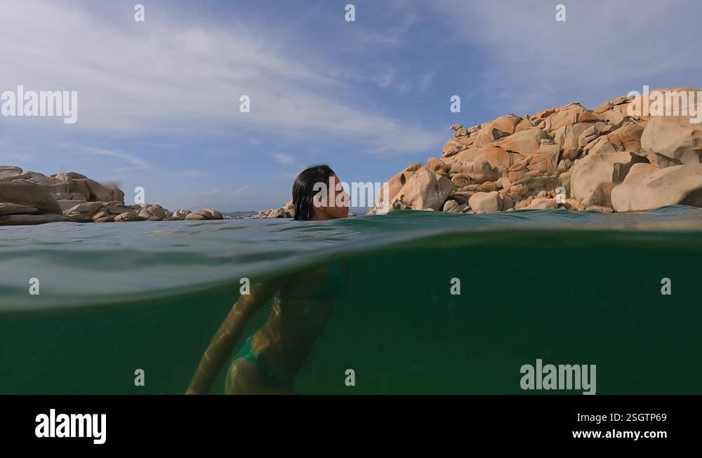 Half underwater scene of woman relaxing while bathing in seawater of ...