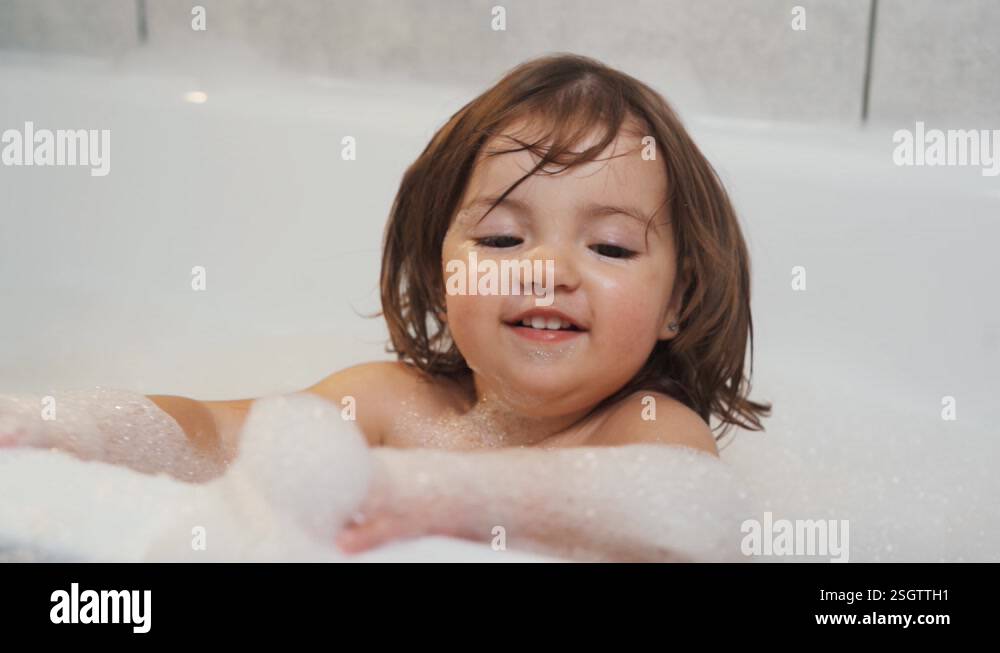 Portrait of a little girl playing with foam in the bath Stock Video ...