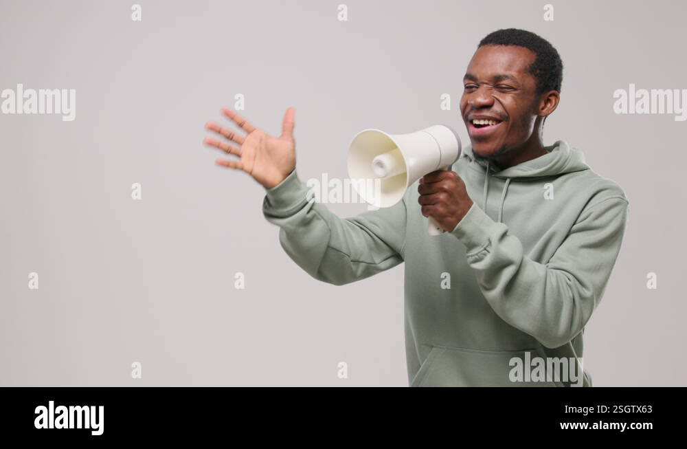 African American guy speaks loudly into megaphone gesticulating with ...