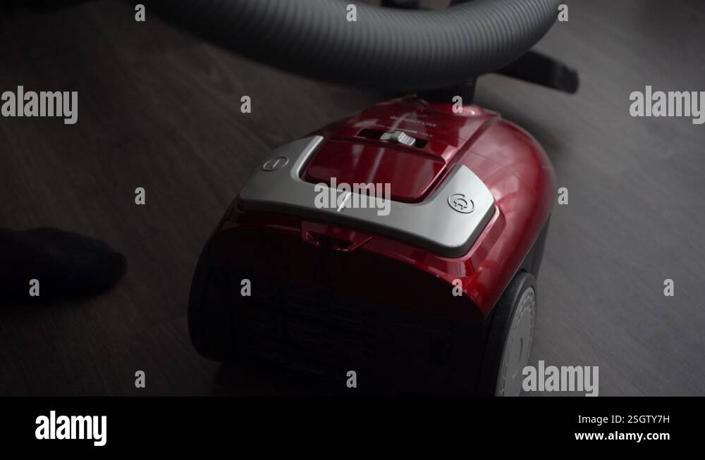 Man uses foot switch to turn on canister vacuum on laminate floor Stock ...