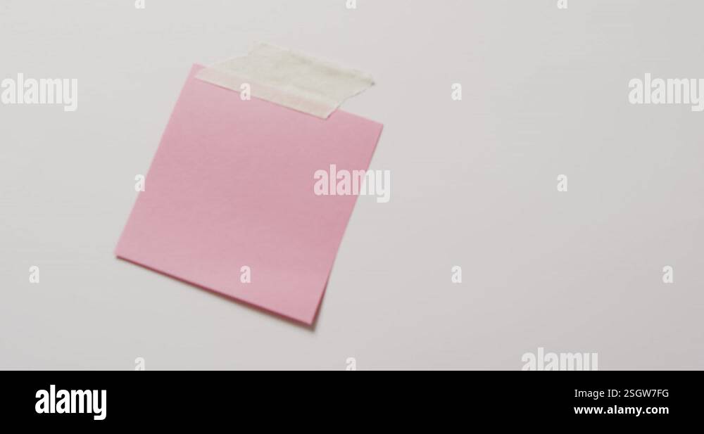 Video of close up of pink memo note with copy space taped to white ...