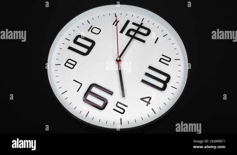 A White Wall Clock On Black Background With A Time Of 5.00 Am Or Pm. A ...