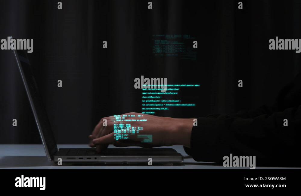 Pogrammer's hands quickly type computer code on a laptop keyboard ...
