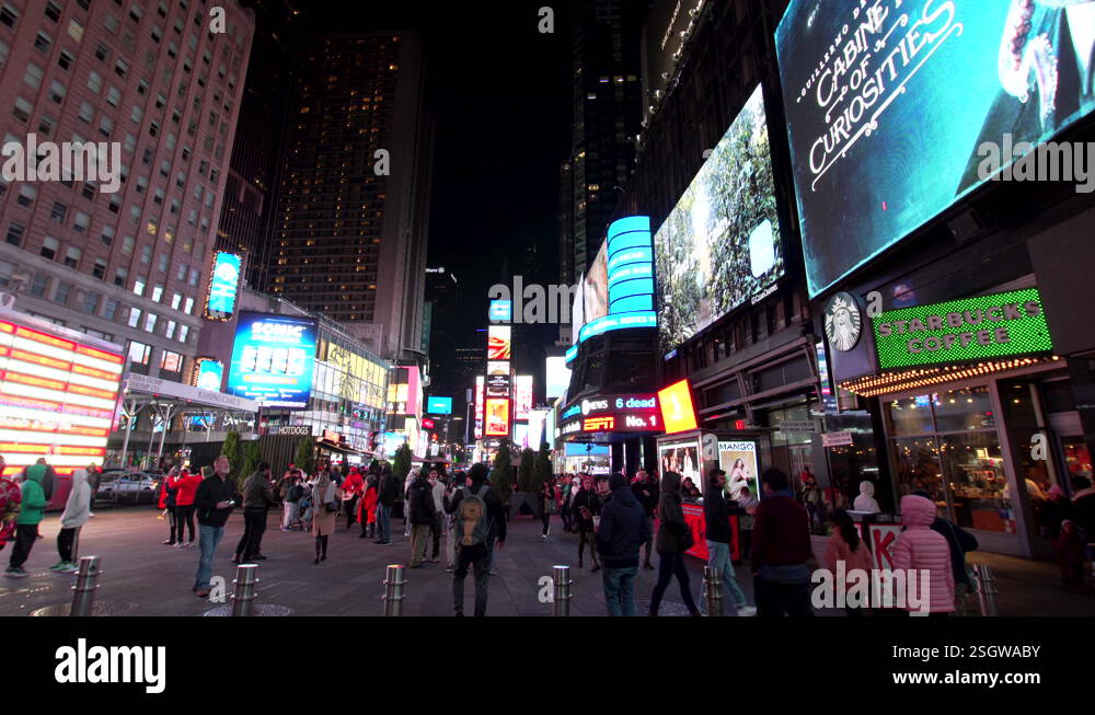 Times Square at night. Starbucks cafe, bright illuminated screens ...