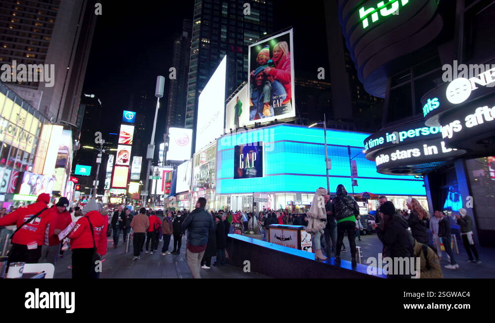 Times Square full of people in the late evening. Cnews crawline, GAP ...