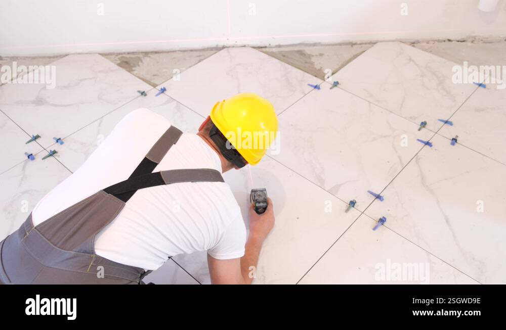 Tiler installs ceramic tiles Stock Videos & Footage - HD and 4K Video Clips - Alamy