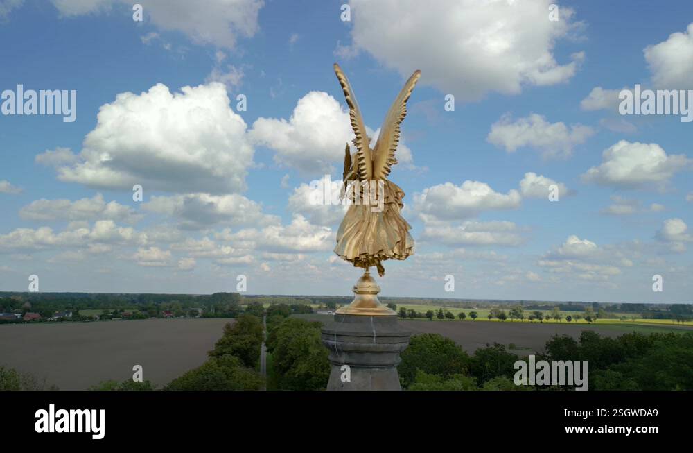 Golden hovering angel figurine with wings sky clouds. Perfect aerial ...