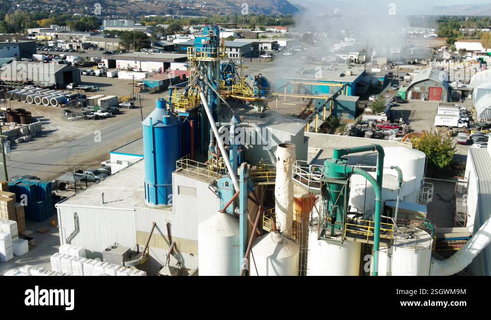 Aerial close pan right shot of large blue Silos on a Industrial Complex ...